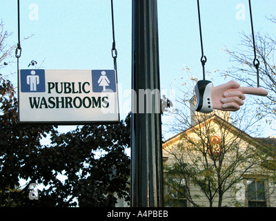 Unique sign with a hand with a pointing to washrooms Stock Photo - Alamy