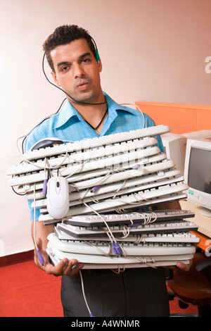 Businessman carrying a large stack of computer keyboards Stock Photo ...