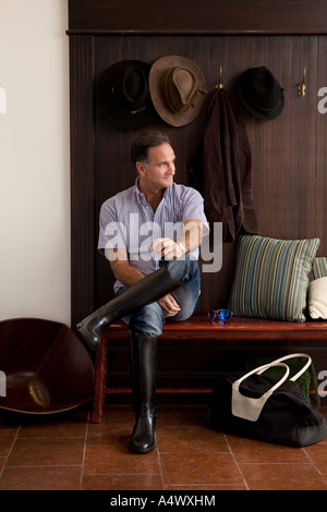 Man wearing riding boots indoors Stock Photo - Alamy
