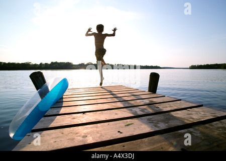 Kids jumping off a dock into a Lake Stock Photo - Alamy