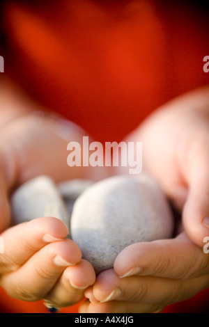 Female hands holding stones Stock Photo - Alamy