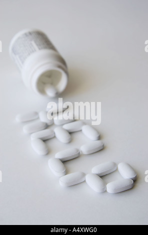 Pills spilled out of a drug bottle. Vitamins pouring out of a ...