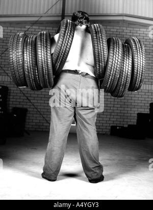 man carrying 8 tyres Stock Photo - Alamy