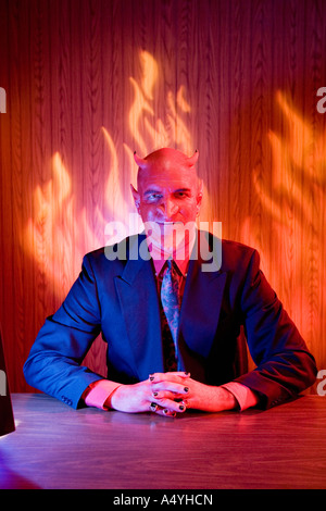 Businessman dressed as devil at desk Stock Photo - Alamy