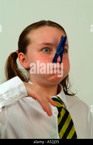 girl wafting hand with peg on her nose with a bad smell Stock Photo - Alamy