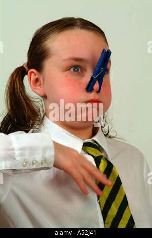 girl wafting hand with peg on her nose with a bad smell Stock Photo - Alamy