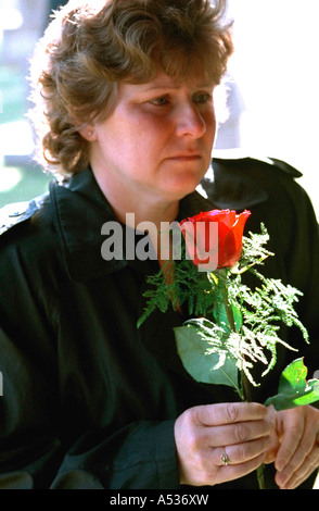 Funeral, cemetery and person with rose on tombstone for remembrance ...