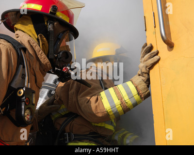 Fire firefighters entering burning building through fire door. One ...