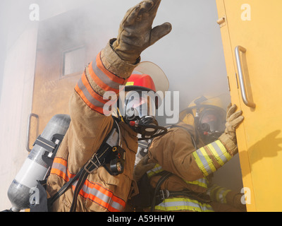 Fire firefighters entering burning building through fire door. One ...