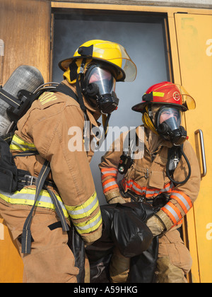Firefighter rescue, Fireman walking out from burning building and hold ...