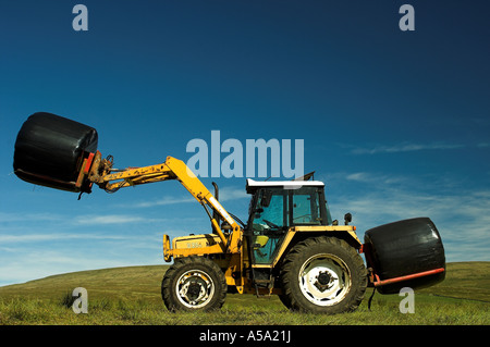 Tractor with hydraulic lift for carrying bales of hay and silage. Front ...