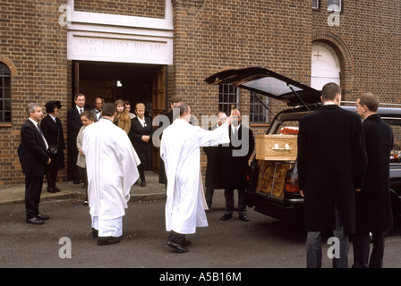 Catholic funeral where priest is blessing the coffin before it is ...