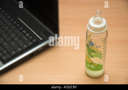 Baby bottle next to laptop on table Stock Photo - Alamy