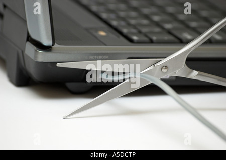 Scissors cutting telephone cable on laptop computer Stock Photo - Alamy