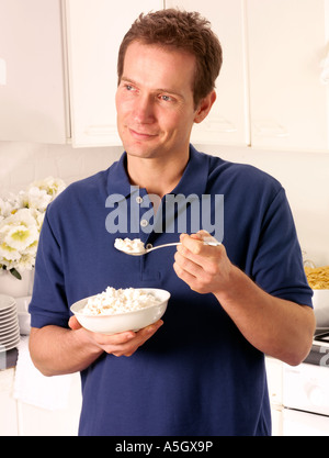 MAN IN KITCHEN EATING COTTAGE CHEESE Stock Photo - Alamy