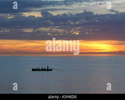 Men rowing in surfboat on sea after sunset helmsman standing Stock ...