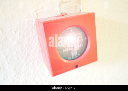 A break glass fire alarm unit containing a gold key with a Pound symbol ...