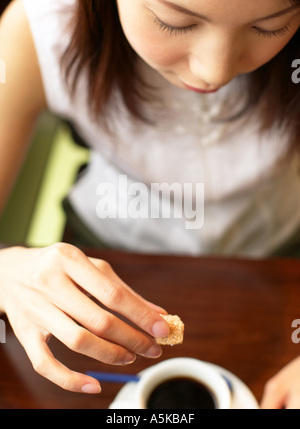 Adding sugar to cup of black tea on wooden table Stock Photo - Alamy