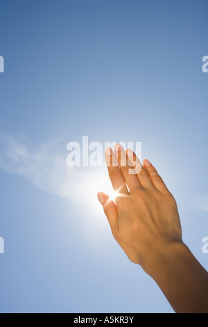 Woman blocking sun with hand Stock Photo - Alamy