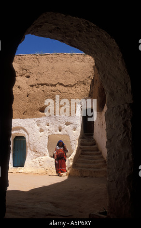 Woman in Berber troglodyte underground home takes shelter in shade from ...
