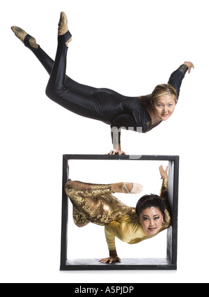 Female contortionist duo with box prop Stock Photo - Alamy