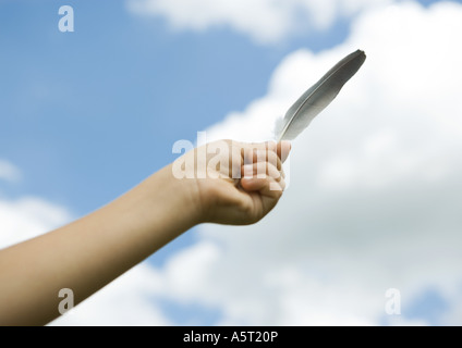 Child's hands holding feathers, close-up, mid section. White feather ...