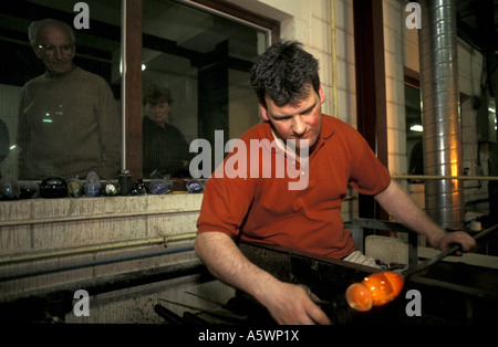 A glass blower in Caithness Glass factory Perth Scotland is watched by ...