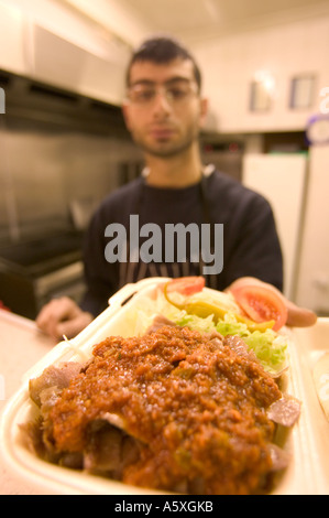 a Turkish man hands over a kebab in a kebab shop, in Lancaster city ...