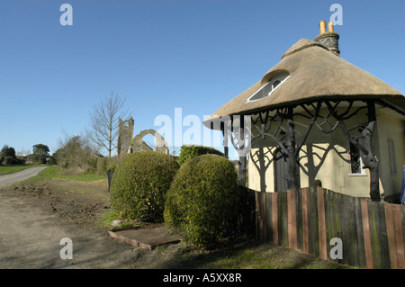 Thatched cottage beside the ruins of St Andrews church Roudham Norfolk ...