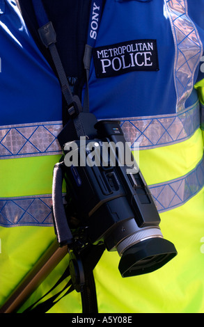 Metropolitan police spotter with video camera looking at his mug shots ...