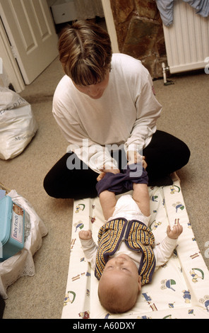 Mother changing babies nappy Stock Photo - Alamy