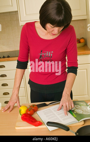 Woman reading recipe book Stock Photo - Alamy