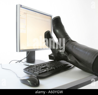 computer workstation with boots on the writing desk during a break ...