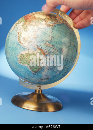 hand turning a globe Stock Photo - Alamy