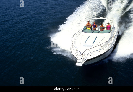 Couples running motor boat with wake and excitement as it moves thru ...