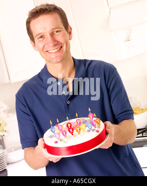 Happy man with birthday cake on color background Stock Photo - Alamy
