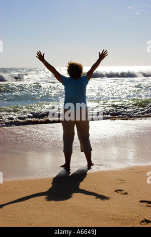 Female silhouette in prayer with hands raised in worship, representing ...