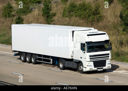 Side view of a white articulated Daf lorry speeding along an English ...