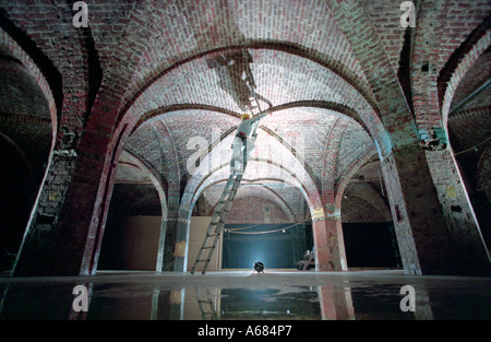 An electrician installying lights in Victorian Gothic style brick ...