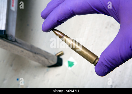 Firearm evidence being collected at crime scene with Sharp's Tongs ...