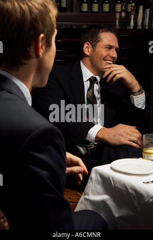 Two business men chat and drink beer at outside bar. Canary Wharf ...