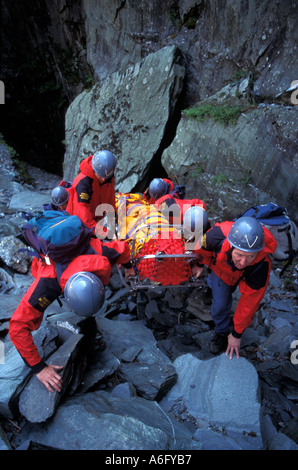 Kendal Mountain Rescue Team carrying a stretcher down the side of a ...