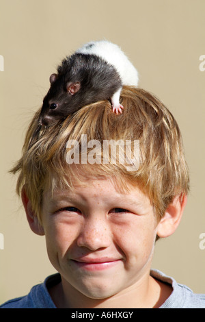 Boy with pet rat Young smiling boy with his pet rat sitting on his ...