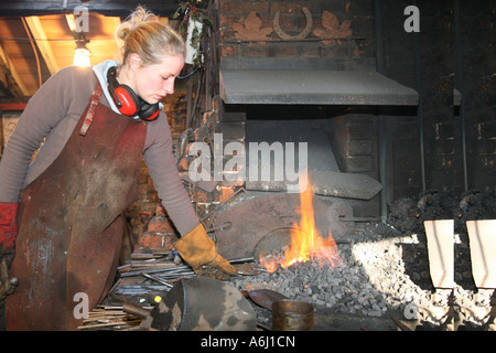 Woman blacksmith working in a forge, Much Hadham, Herfordshire, England ...