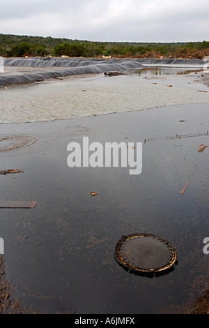 Crude oil in holding pits on an oil field in West Texas waste from a ...
