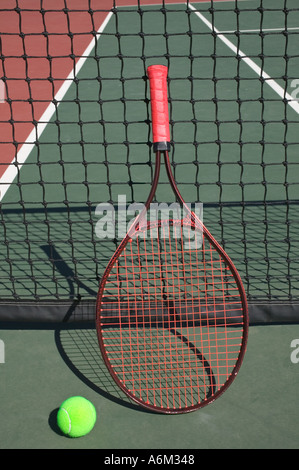 Tennis rackets, ball leaning against net Stock Photo - Alamy