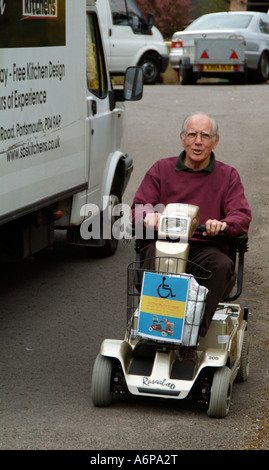 An elderly man riding his Rascal electric scooter leaning into the ...