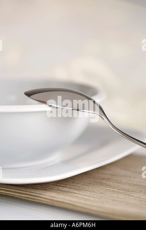 Soup plate with spoon on setting utensil Stock Photo - Alamy