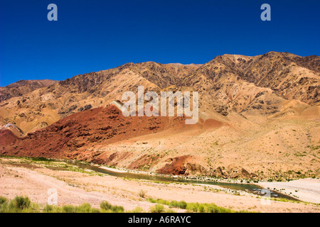 Hari Rud river through fertile valley at base of red rock mountains ...