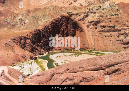 Hari Rud river through fertile valley at base of red rock mountains ...